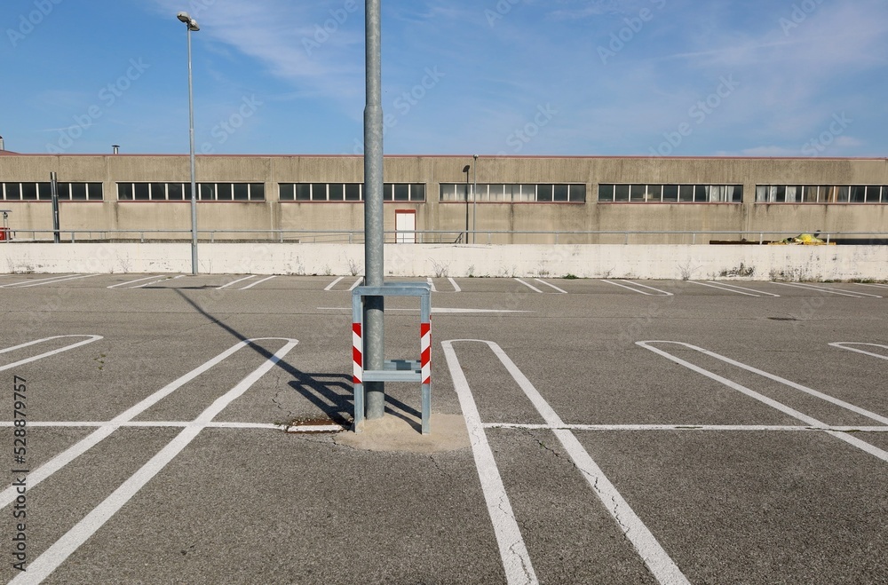 Large empty parking lot with a pole and road fence in the middle and a ...