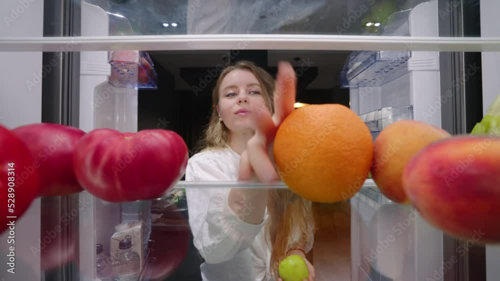 View from inside fridge - woman opens side by side fridge doors, takes ...