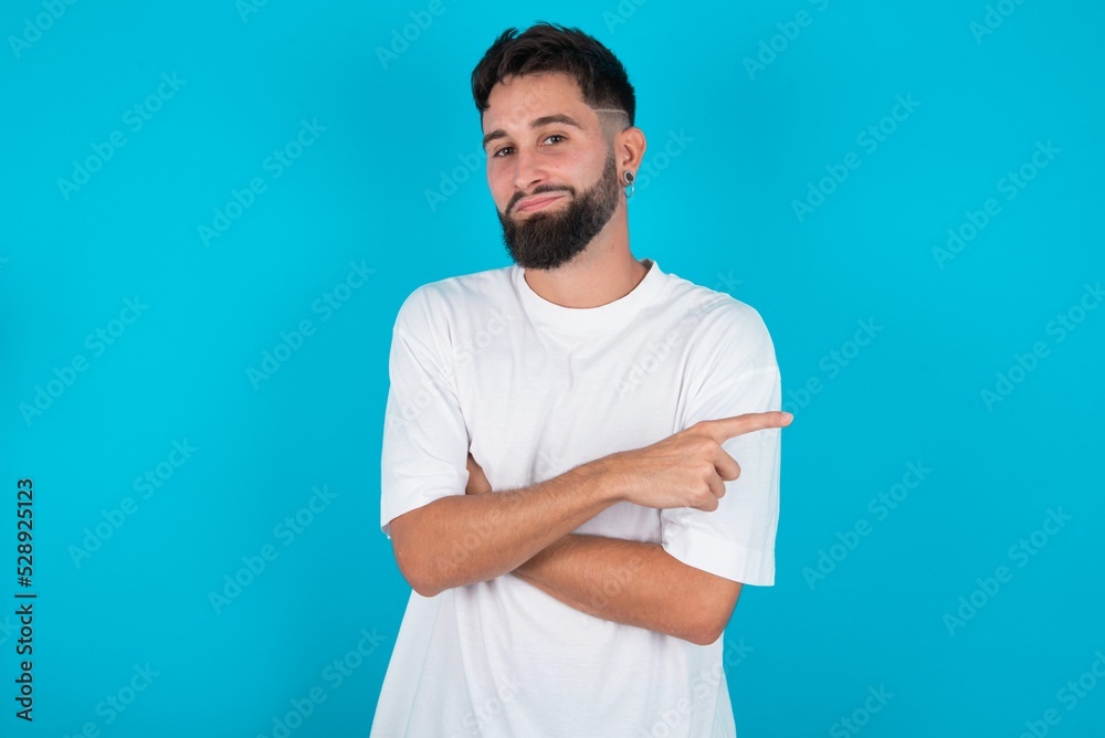 bearded caucasian man wearing white T-shirt over blue background ...