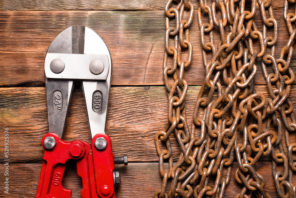 Bolt cutters rebar shears and iron chain on brown wooden workbench ...