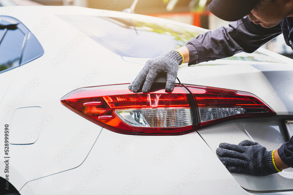 Car mechanic checking tail lights Adjust the brake lights by a mechanic ...