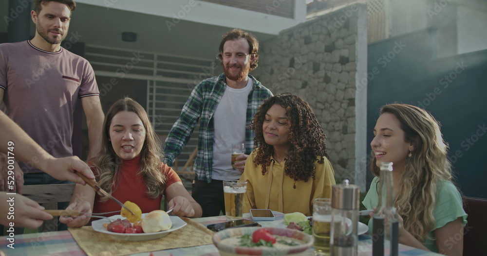 Family members and friends together at home backyard having barbecue in ...