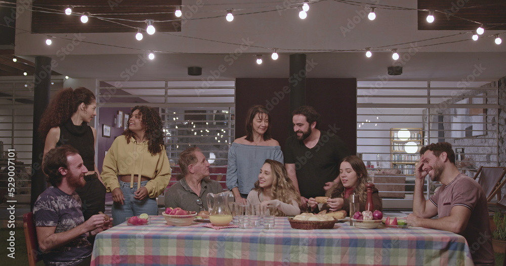 Group of happy people are sitting together in the backyard of the house ...