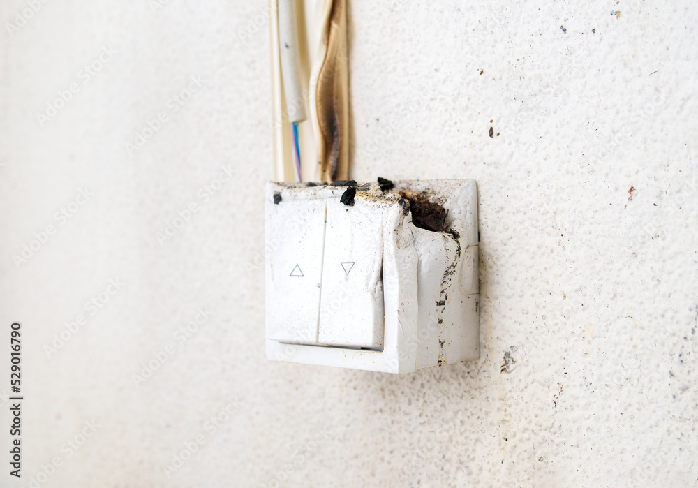 Melted light switch with fire damage, close up. Light regulator mounted ...