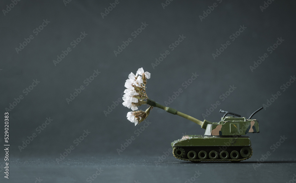 Model toy of battle tank firing flowers from the barrel. Peace and no ...