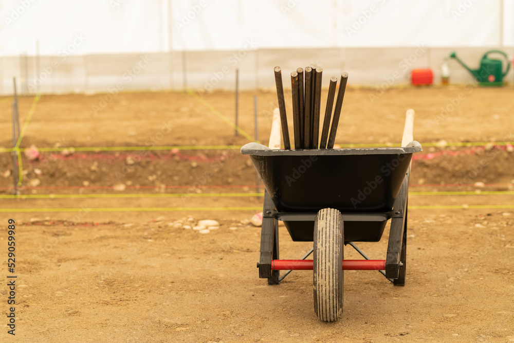 Construction wheelbarrow standing beside gravel and concrete curb ...
