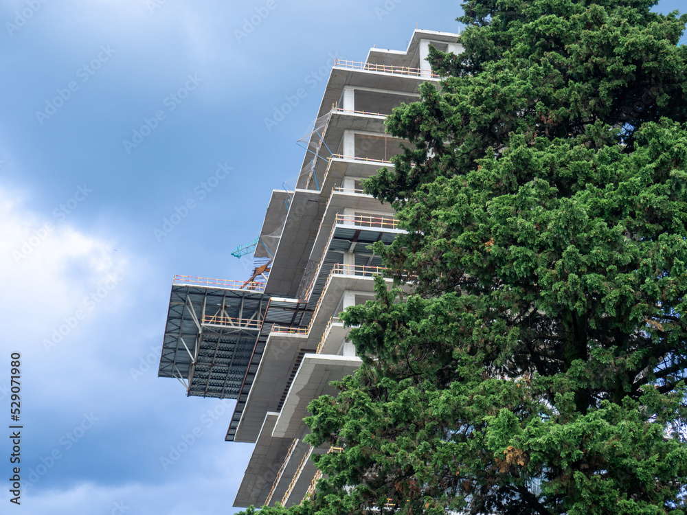 Part of the construction of a tall building. House and nature. House ...