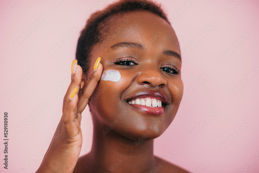 Beautiful black african model with flawless skin putting cream ...