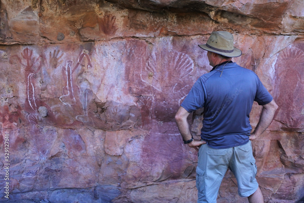 Australian man looking at Australian Aboriginal mythology rock ...
