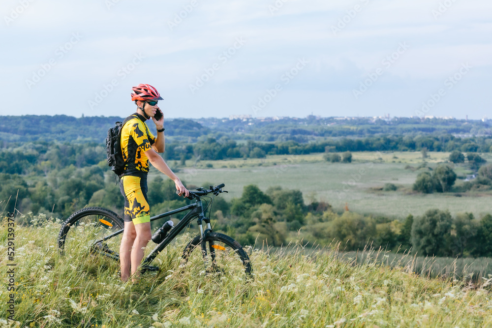 Happy male cyclist sending a text message on his mobile phone. Image of ...