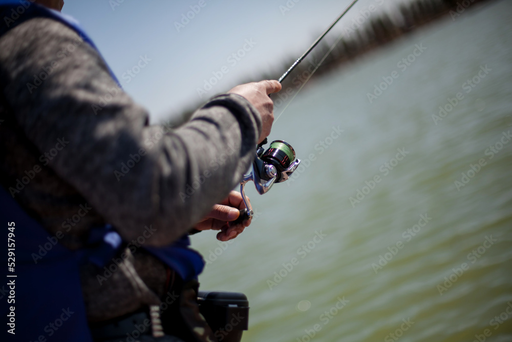 Caucasian fisherman holds a spinning rod in his hands, close-up. Sport ...
