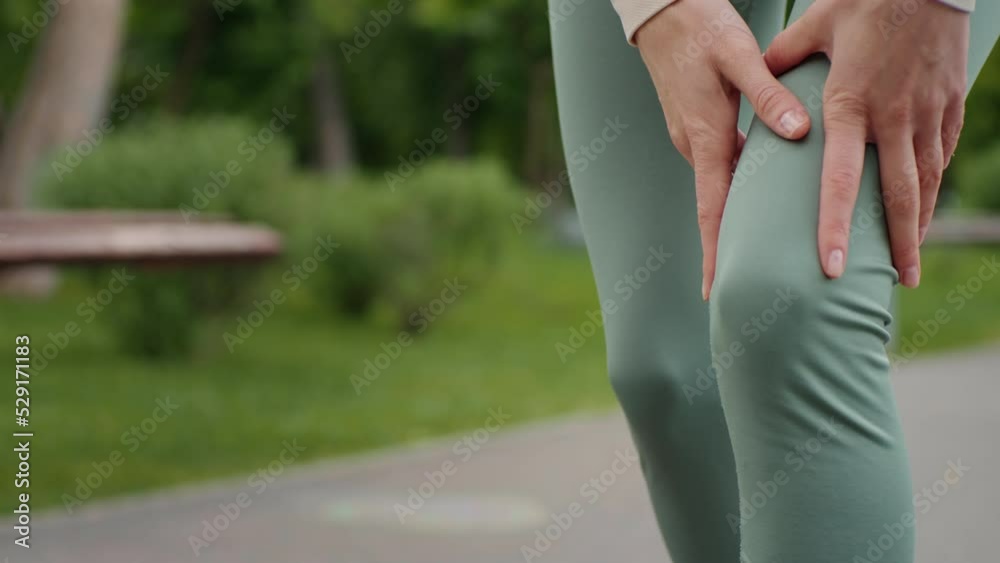 Female legs feeling knee pain while running. Close-up female legs in ...