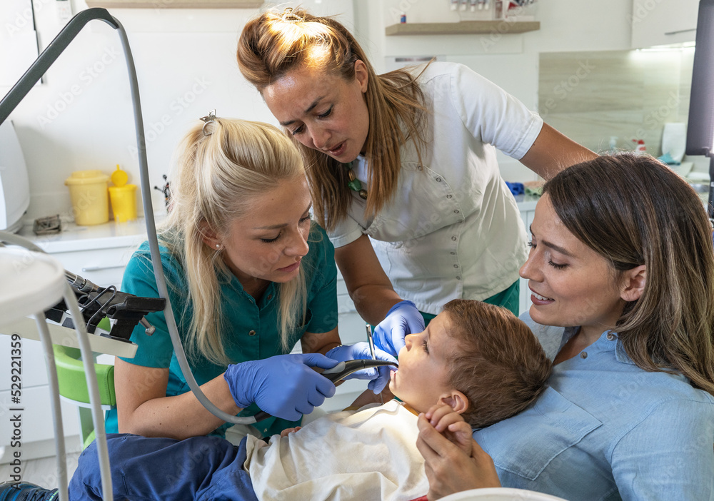 Little boy doing a teeth examination by a professional specialist in a ...
