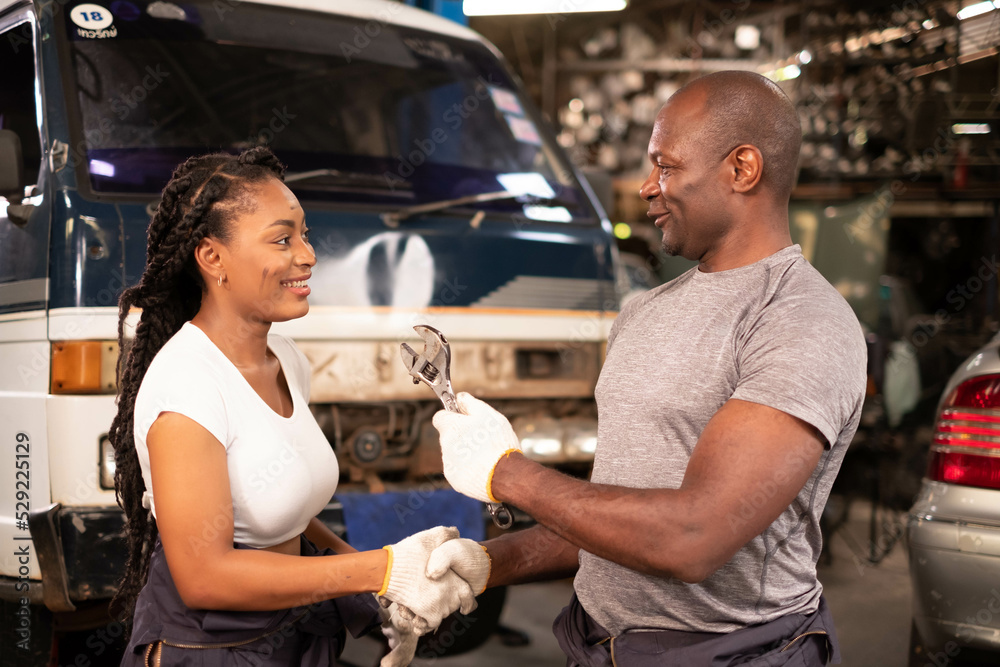 Foto de African american Two mechanics - man examining car engine. Auto ...