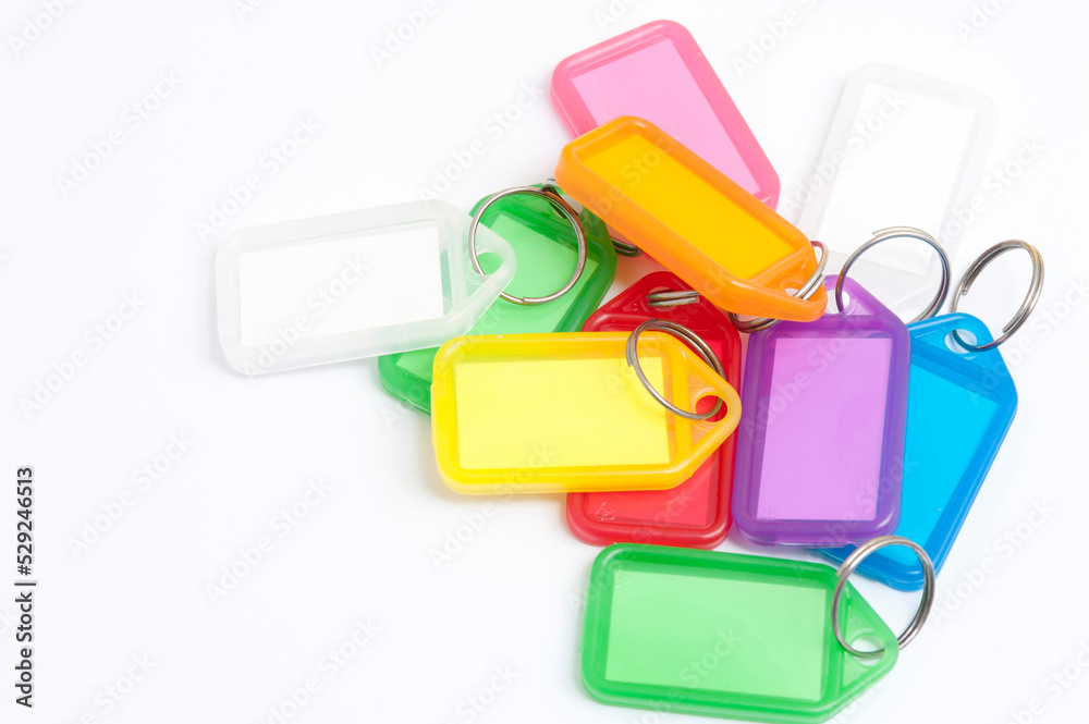 Pile of colourful plastic key tags with blank labels for organising and ...