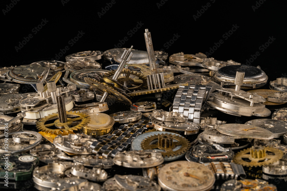 Heap of metal internal parts of an old clock. Dial, clockwork, bracelet ...