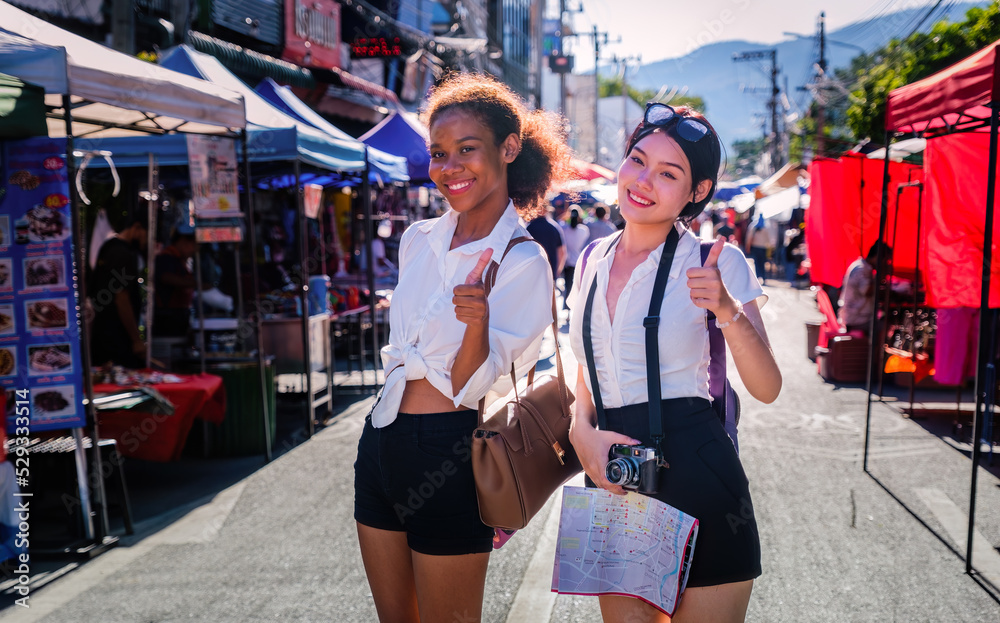 Young women enjoy street market and shopping the souvenirs in the city ...