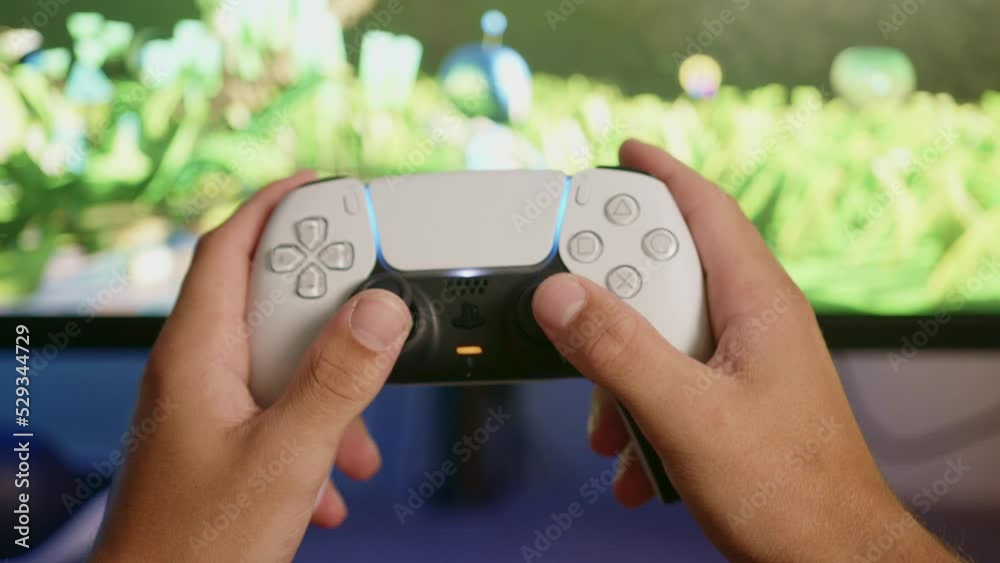 Boy picking up his PS5 controller to start gaming on his PlayStation 5 ...