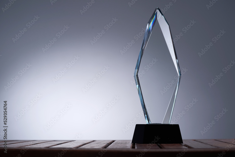 glass trophy on wood table against gray background Stock Photo | Adobe ...