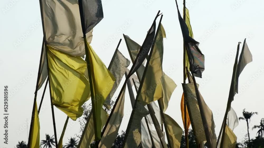 A group of flags are swinging in slow motion, the camera is moving up ...
