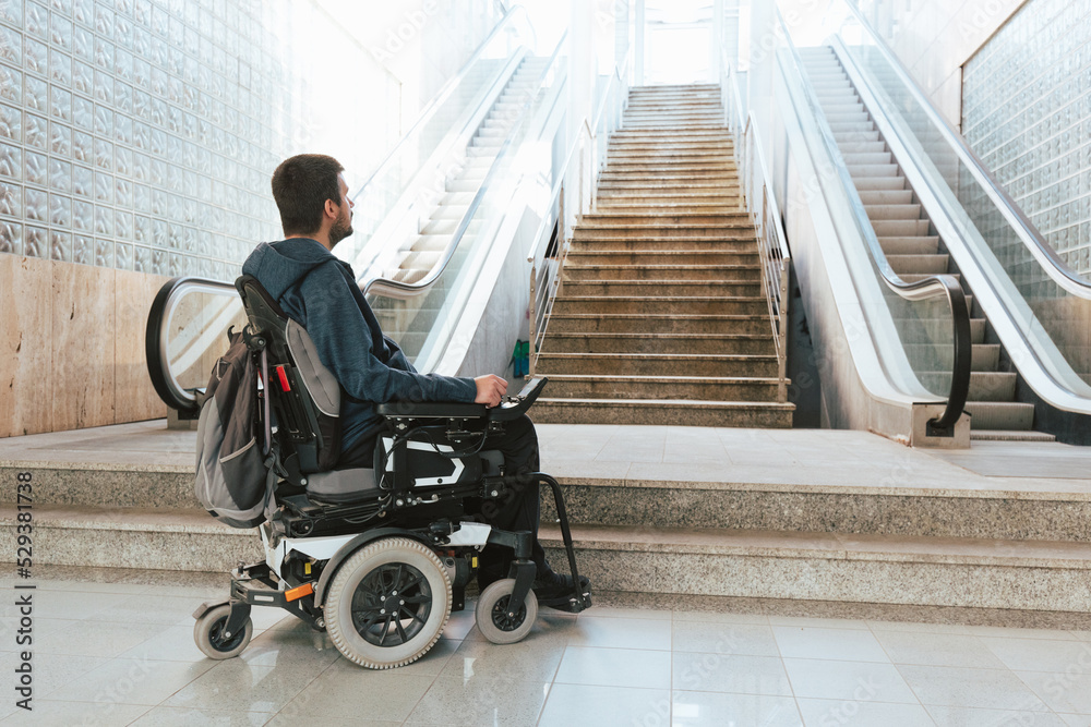 Man with disability on wheelchair stopped in front of staircase ...