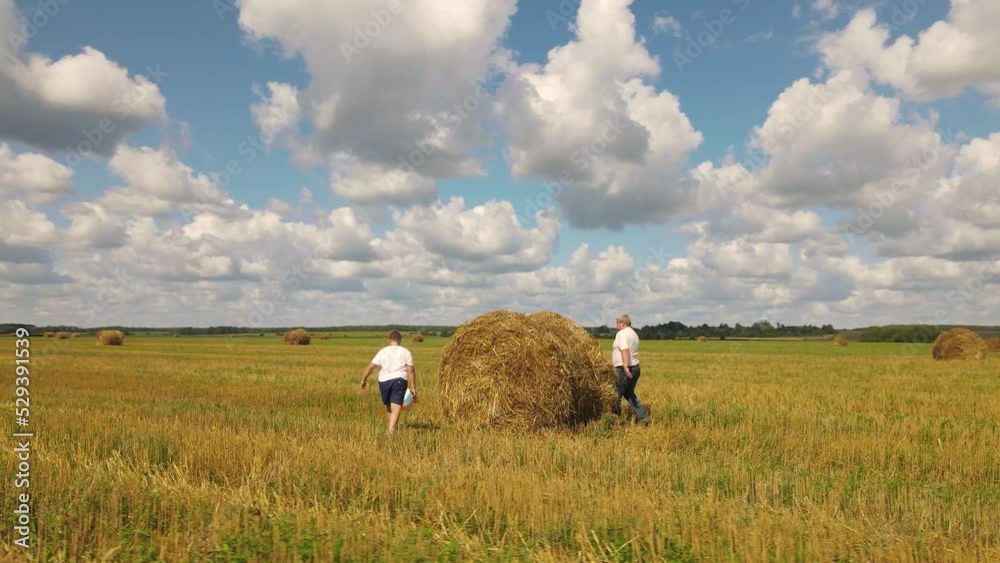 Mom, dad and son run around the haystack and play, aerial view. A ...