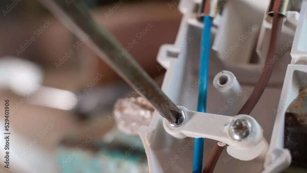 Blue and brown wires are clamped with a screwdriver in the plug housing ...