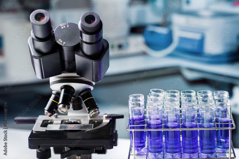 Microscope and rack with sample tubes in the workbench of Microbiology ...