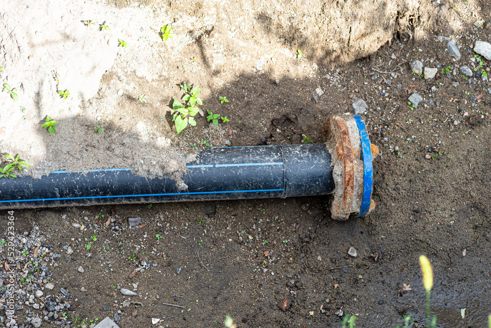 Foto de Closed end of a plastic water pipe lying along a ditch with ...