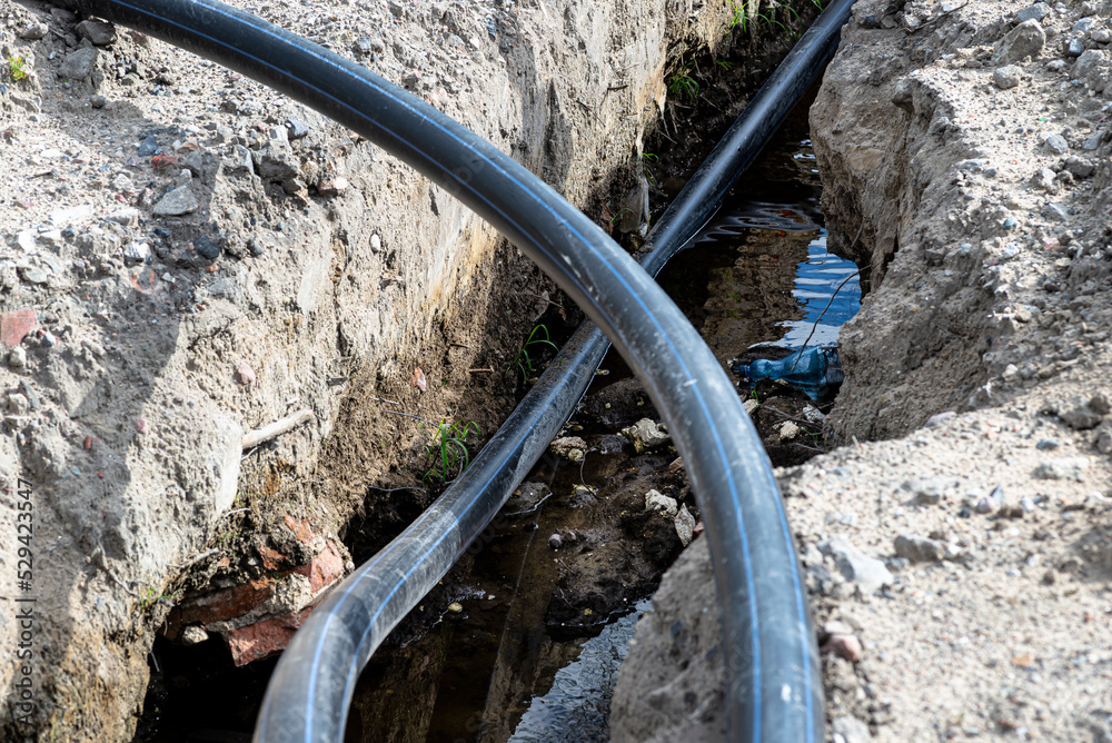 Plastic water pipe lying in a ditch with high groundwater, water ...