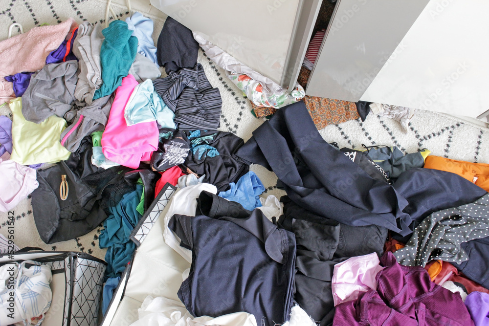 Above view of a messy bedroom floor with clothes overflowing from the ...