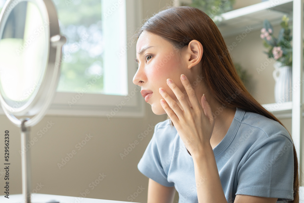 Foto Stock Dermatology, scratch asian young woman looking at mirror ...