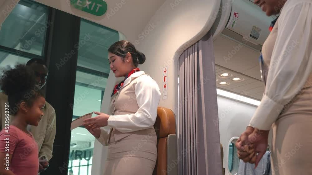 Asian flight attendants greeting welcoming passengers walking and ...