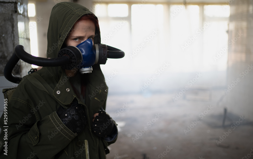 Young pandemic survivalist woman in gas mask looking in front of her on ...