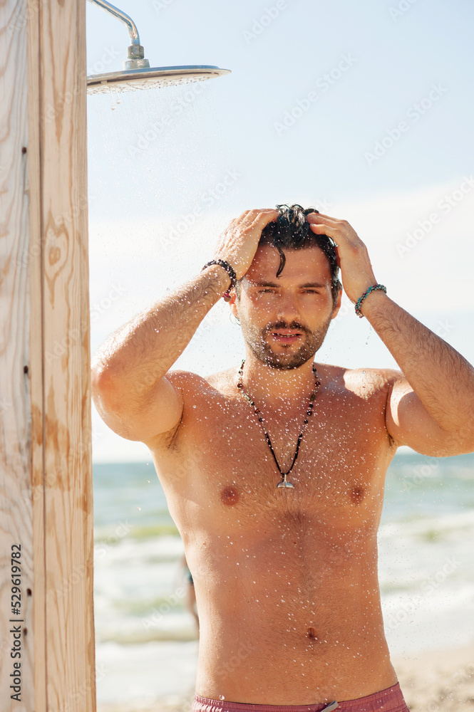Handsome attractive men with languishing look showering outdoor in ...