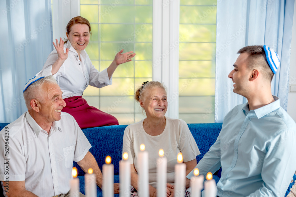 Jewish family celebrates Hanukkah. A senior man and young guy wear ...