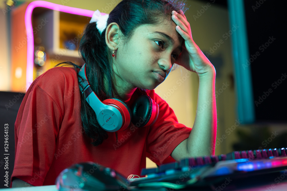 Sad teenage girl with headset due to losing in game while playing ...