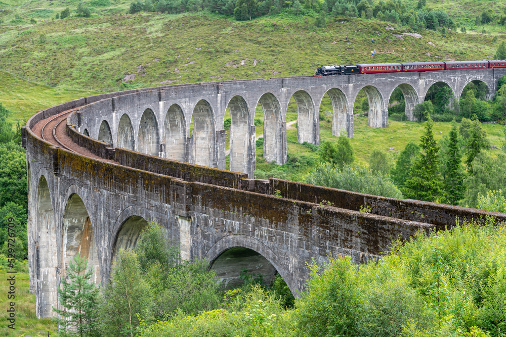 Jacobite steam train,entering Glenfinnan Viaduct,set amongst Scottish ...