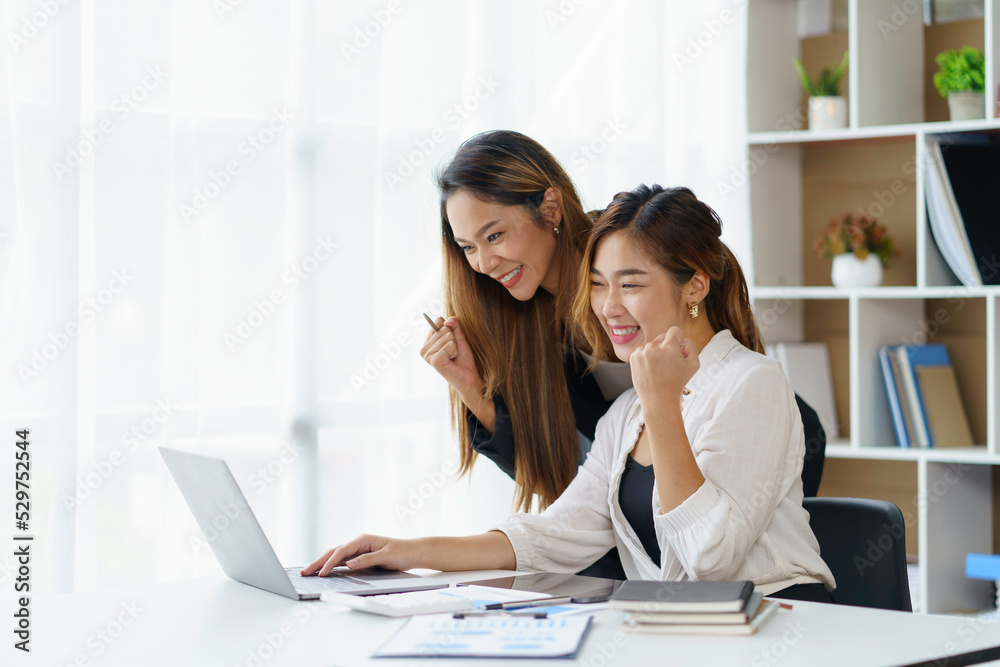 Happy two Asian business women raising their hand to congratulate their ...