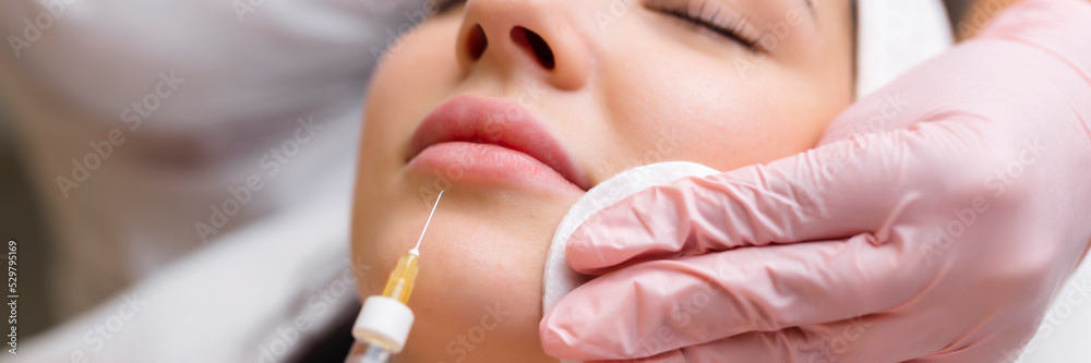 lip shape correction procedure in a cosmetology salon. The specialist ...