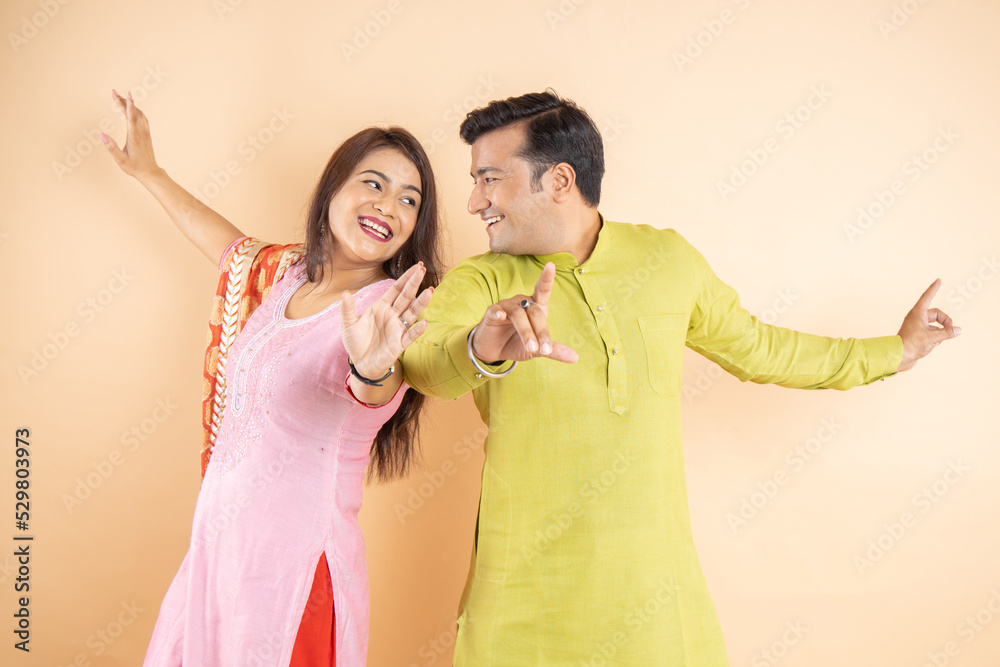 Happy indian couple dancing together wearing traditional or ethnic ...