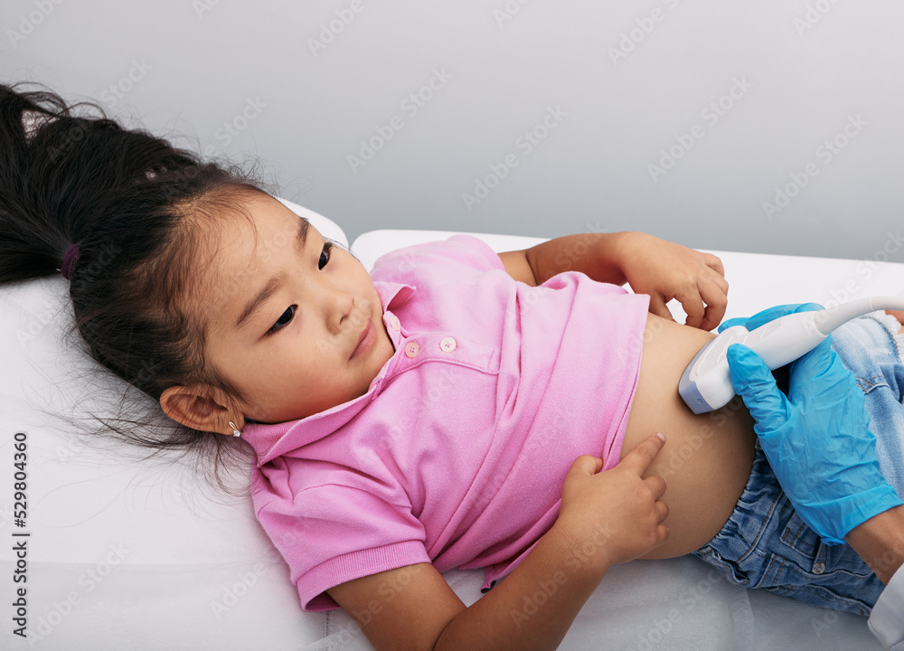 Asian little girl patient receives belly diagnostics with ultrasound ...