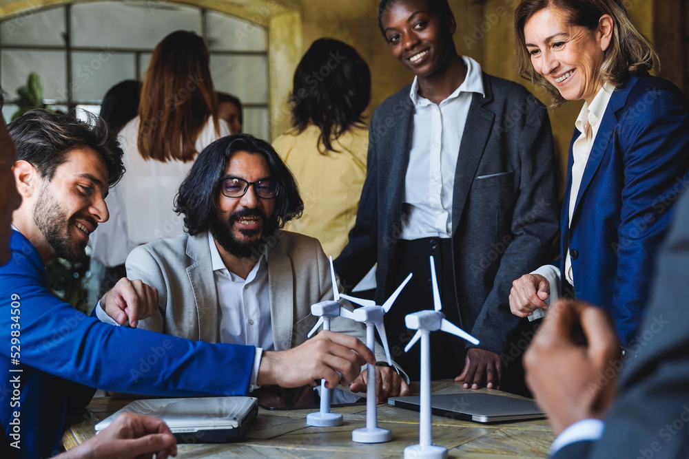 Multiethnic business people working on sustainable renewable energy project inside office ...