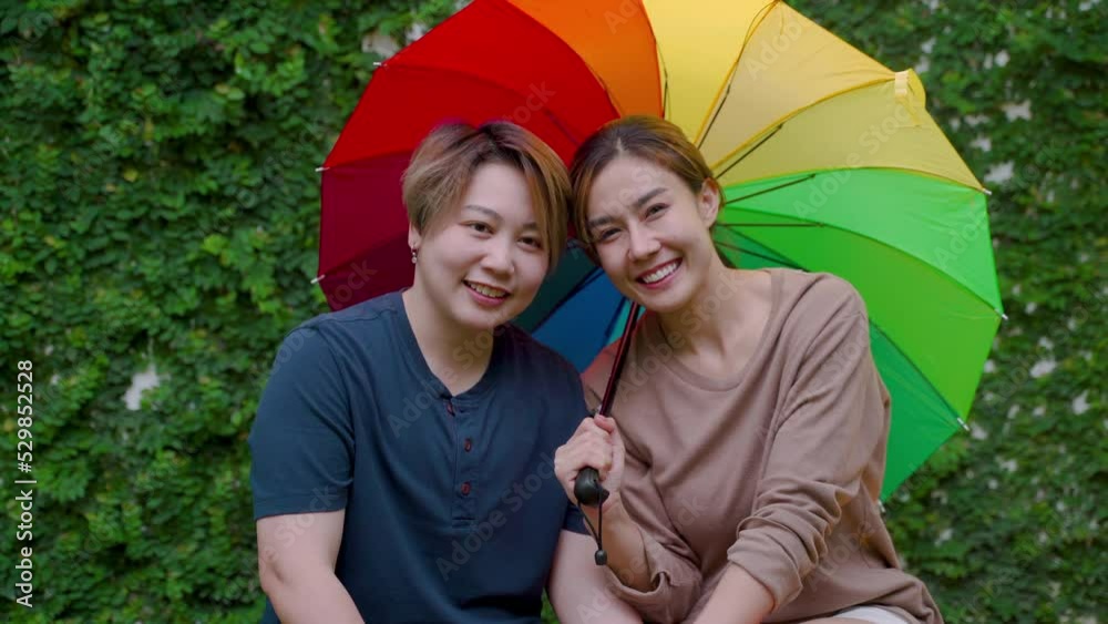 4K, Two Asian women of the same sex are sitting under colorful ...