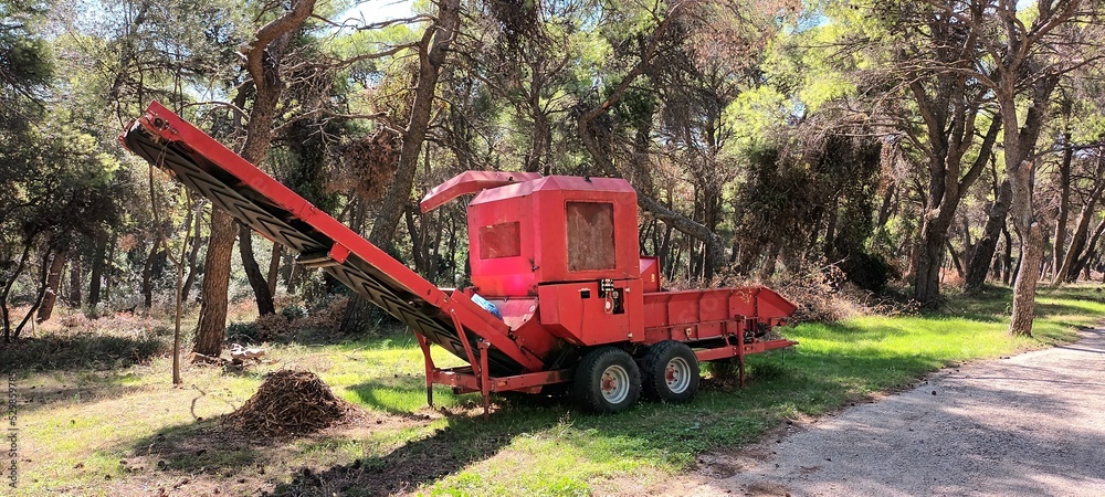 Industrial wood chipper placed inside a forest for shredding biomass ...