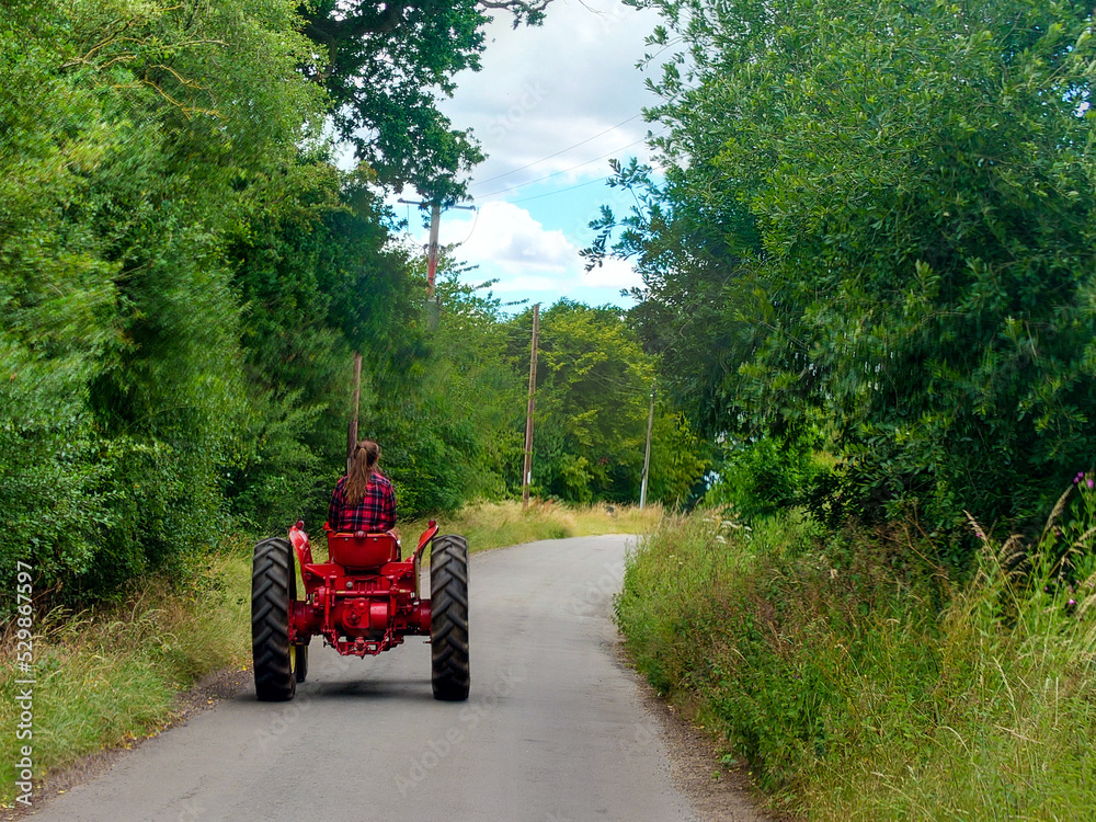 Young women driving a vintage tractor down country roads Stock Photo ...