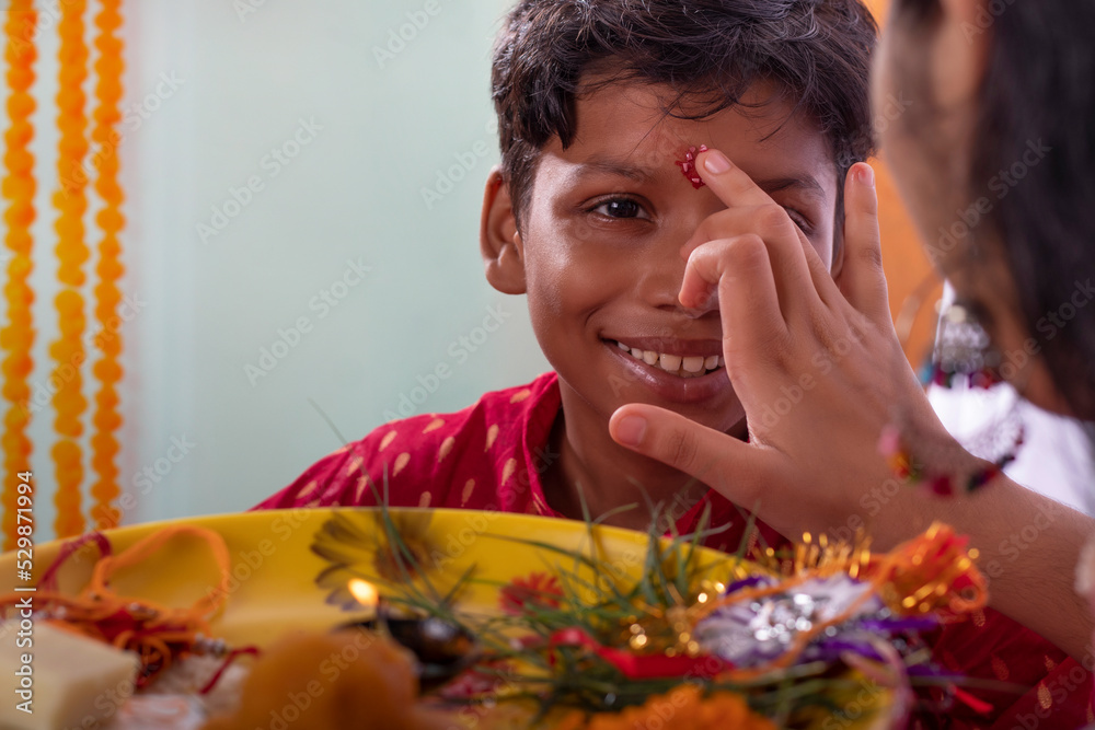 Sister applying tika on her brother's forehead on the occasion of ...
