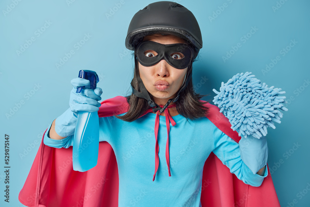 Wondered woman dressed in superhero costume keeps lips folded holds ...