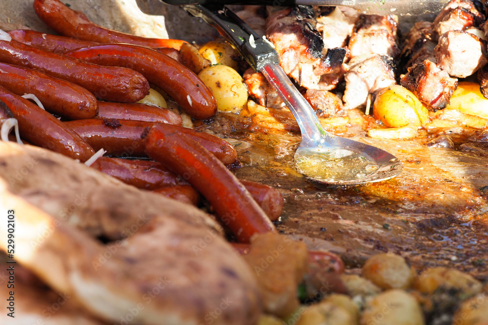 Very greasy food cooked over an open fire at a street food festival ...