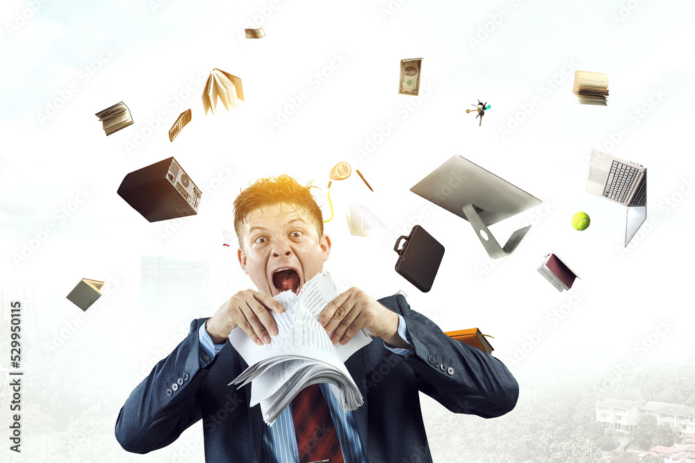 Young stressed man ripping documents with frustrated facial expression ...